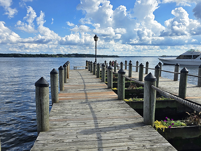 The wooden pier stretches toward the horizon like an invitation to adventure, each weathered plank telling stories of lake journeys.