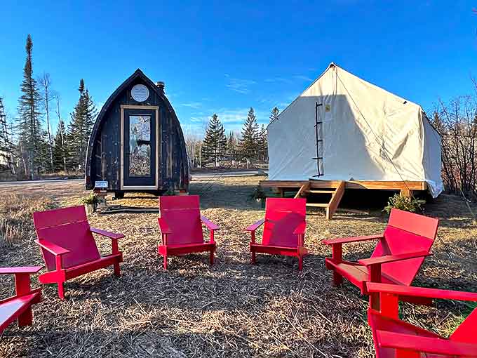 Vibrant Adirondack chairs form a fireside circle, inviting stories and laughter to flow as freely as the nearby waters.