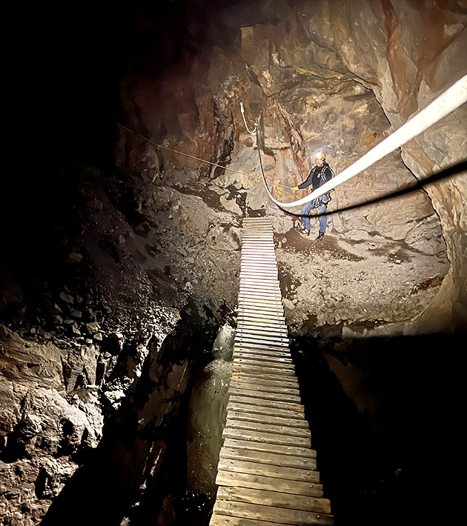 Follow the wooden path into the unknown &ndash; these planks bridge present and past in the cool, mineral-scented darkness.