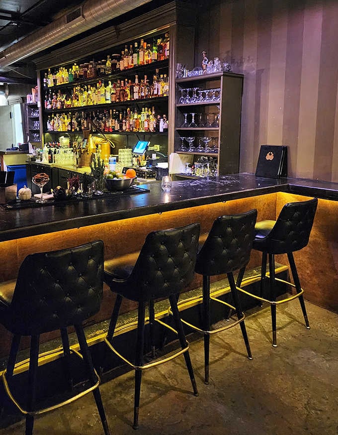 Bar Area: Bottles gleam like liquid treasure behind this mixology altar where bartenders craft liquid poetry with scientific precision.