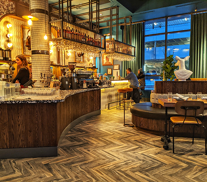 Bottles glow like jewels against the backlit bar, where mixologists craft cocktails worthy of the innovative food menu.