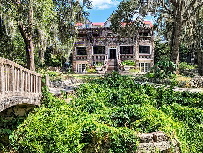 The mansion looms beyond another garden bridge, creating a sense of journey and discovery as you explore the grounds.