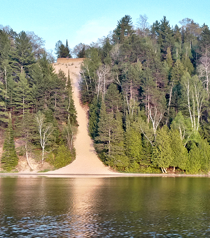 Champagne Hill lives up to its bubbly name, with a sandy slope that seems to fizz with golden light as it rises from the blue waters below.