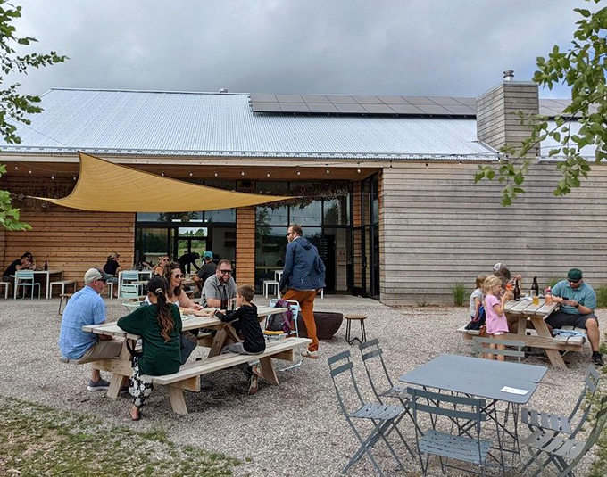 Families gather at wooden tables outside the modern farmhouse, where meals become memories against a backdrop of rolling fields.