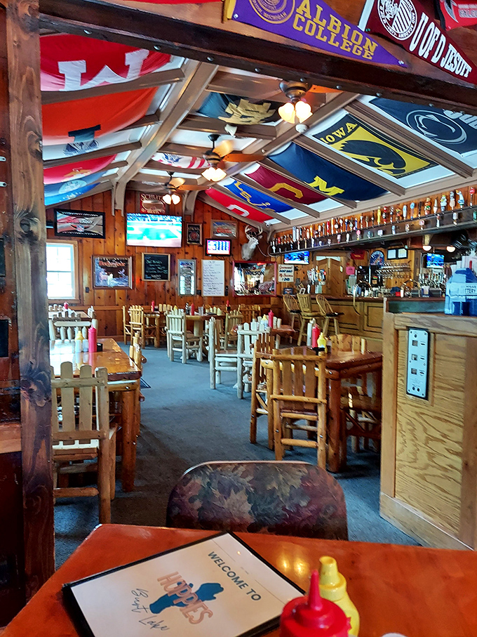 College flags and sports memorabilia create a vibrant ceiling in the dining area, where every meal feels like a small celebration.