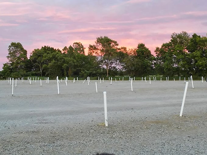 Sunset paints the sky in watercolor hues above the Capri's parking area, white poles standing like sentinels guiding moviegoers to their spots.