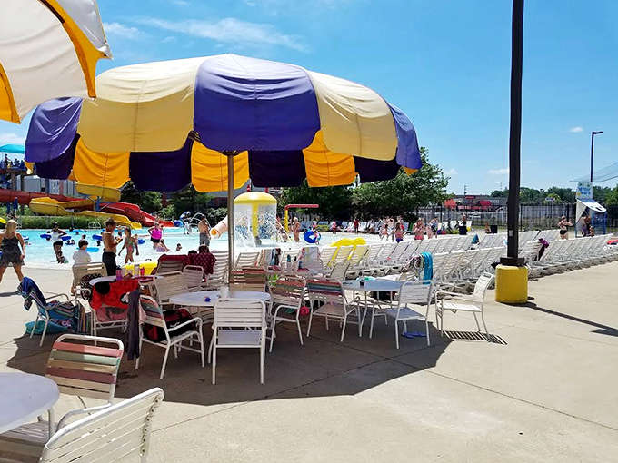Colorful umbrellas and lounge chairs create a festive atmosphere where claiming the perfect spot becomes part of the day's strategy.