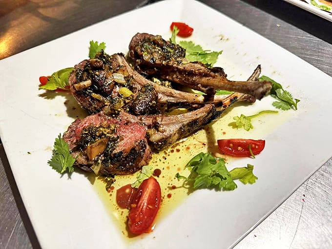 Grilled Lamb Chops: Succulent lamb chops glisten with herb-infused oil, artfully arranged on the plate like delicious little meat lollipops for sophisticated palates.