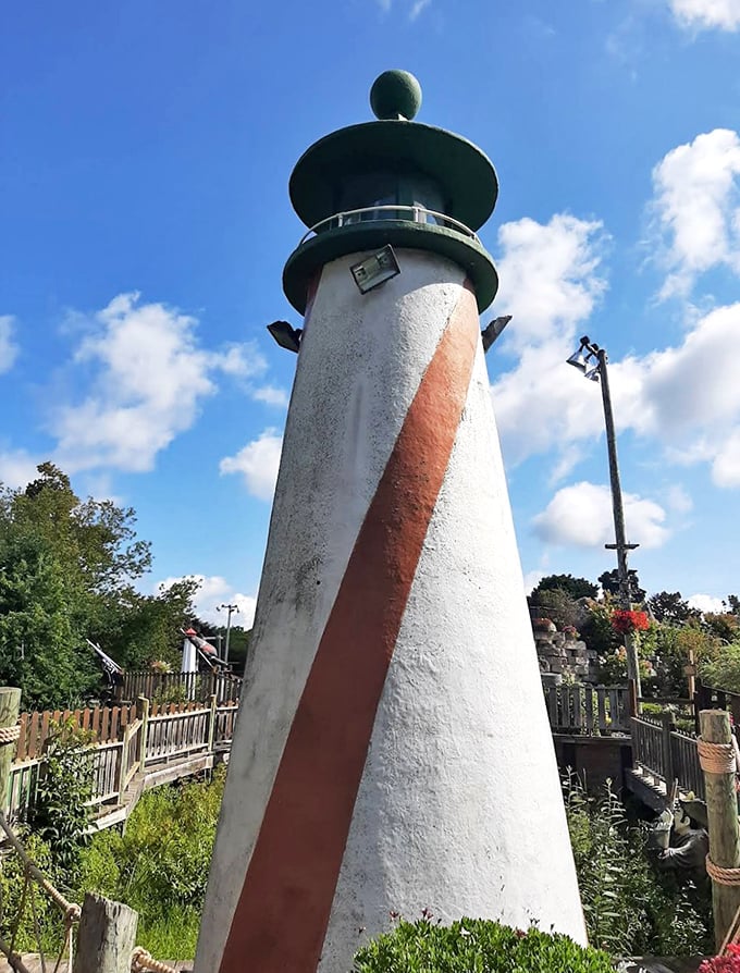 The lighthouse stands as a beacon of hope for lost putters, its classic red and white stripes a navigation aid for mini-golf mariners.