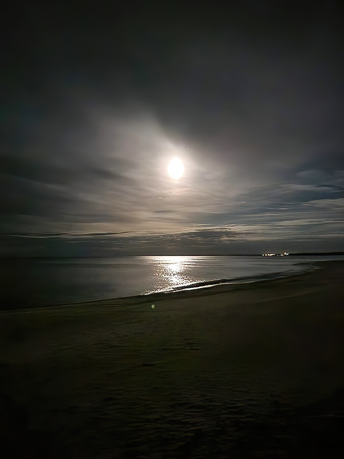 Moonlight creates a silver highway across Lake Huron's surface, turning Agate Beach into a magical nighttime landscape of shadows and light.