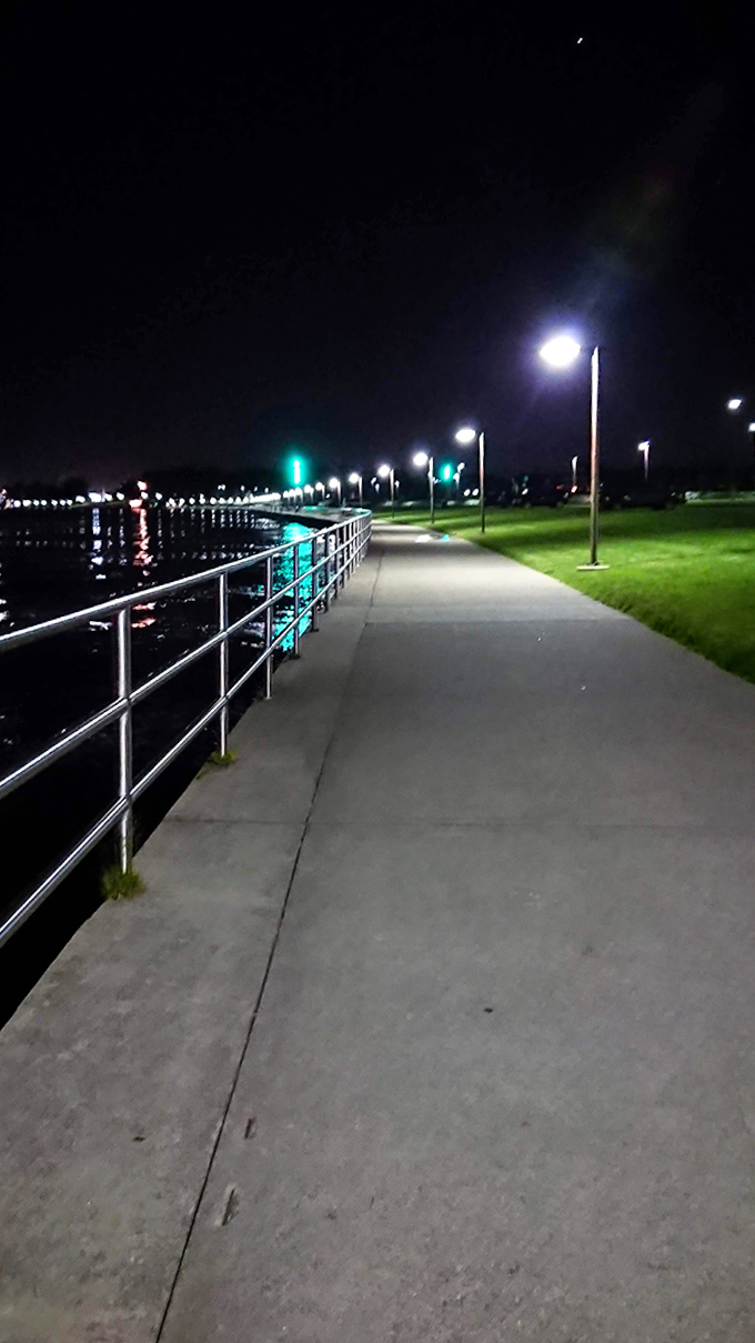 After sunset, the illuminated pathway transforms into a magical ribbon of light, guiding evening explorers along the water's edge.