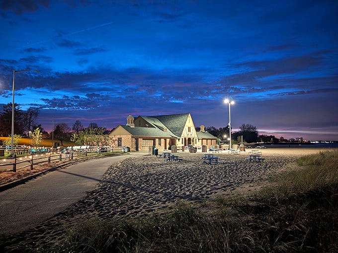 Simmons Island Beach House glows at twilight, offering refreshments and shelter for beachgoers extending their stay into evening hours.