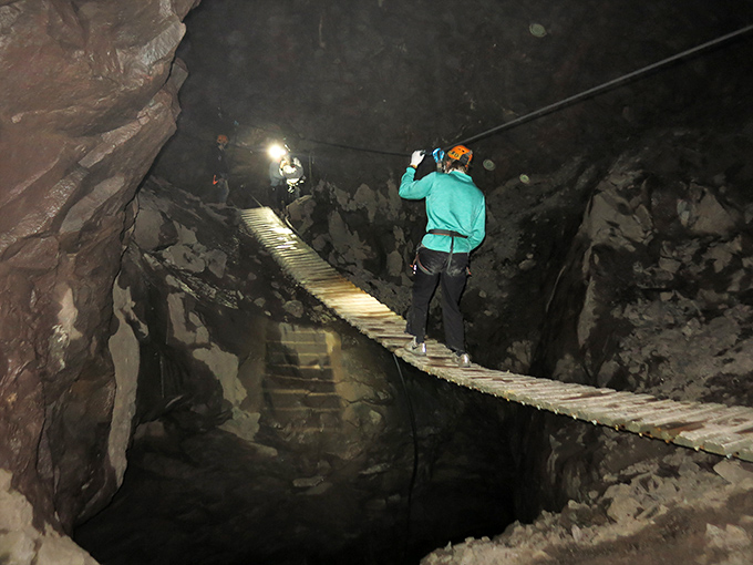 Suspended between adventure and anxiety, explorers navigate a wooden bridge that would make Indiana Jones think twice.