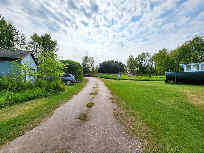 The humble entrance path belies the historical treasure at its end &ndash; nature slowly reclaiming edges of a gravel road that's welcomed visitors for generations.