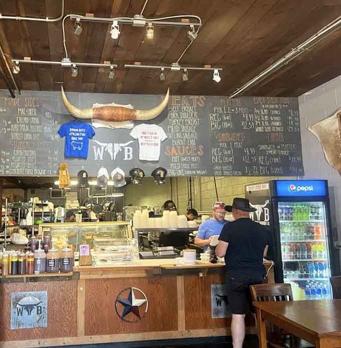 The ordering counter where barbecue dreams come true, complete with longhorn logo and a menu board listing smoky treasures.