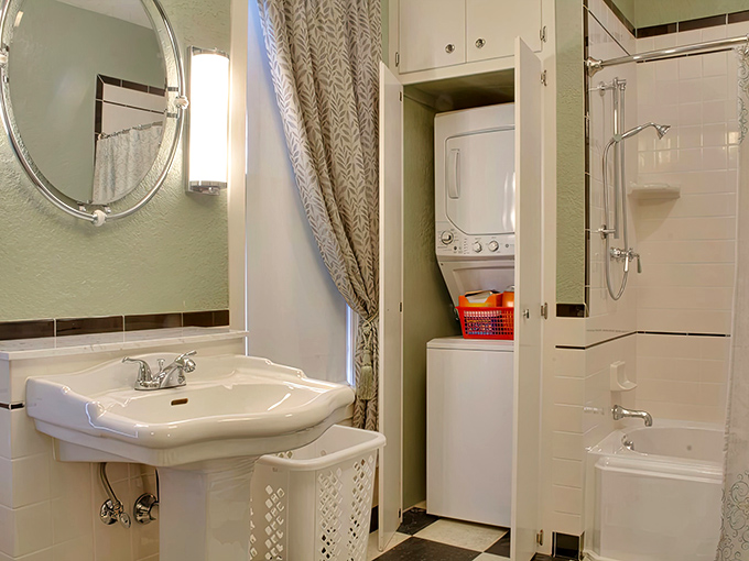 Even the bathroom maintains period charm with classic fixtures and clever storage solutions hidden behind cabinet doors.