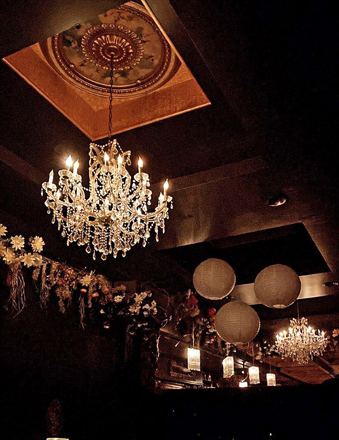 Ornate ceiling medallions and crystal chandeliers create a canopy of elegance above, while comfortable seating invites you to settle in for a memorable evening.