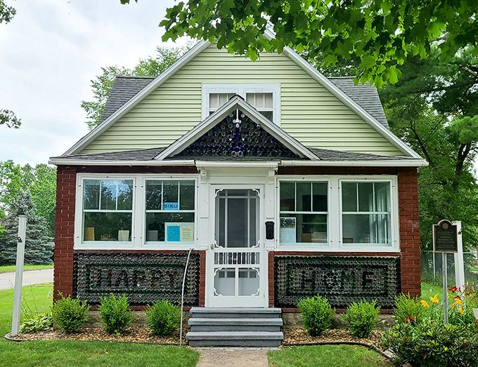 The front facade proudly displays "HAPPY HOME" spelled out in bottles &ndash; an architectural welcome mat that's stood the test of time.