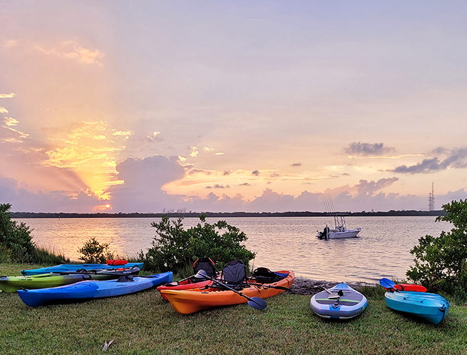Sunset transforms the bay into a painter's dream, with colorful kayaks waiting patiently for tomorrow's adventures.