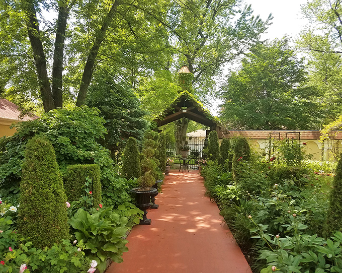 Garden pathways lined with perfectly manicured greenery lead visitors on a journey of discovery between monastery buildings.