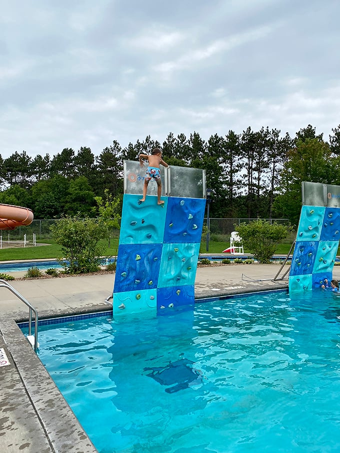 The climbing wall emerges from crystal waters like a modern-day Excalibur, daring visitors to test their grip against its slippery challenge.