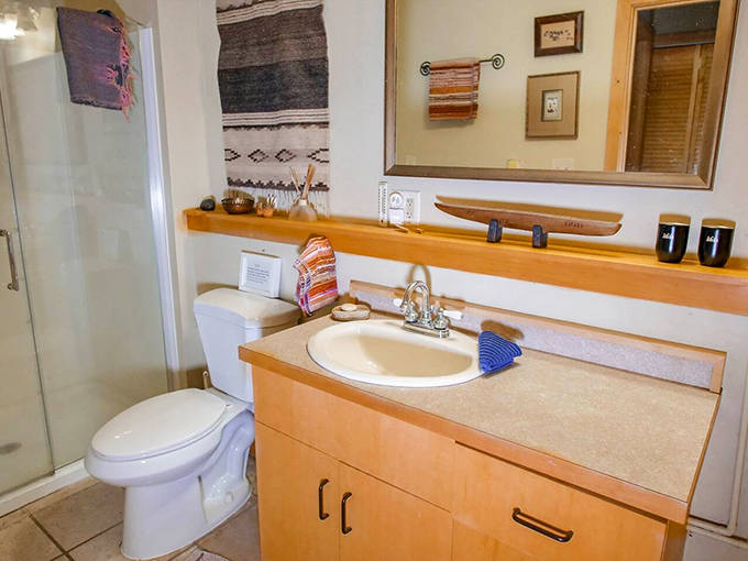 Even the bathroom maintains the cabin's warm aesthetic, proving functional spaces can still contribute to vacation vibes.