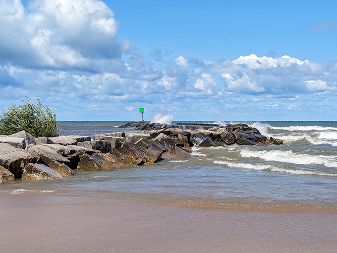 Waves crash dramatically against the rocky breakwater, a reminder of Lake Michigan's power and beauty.