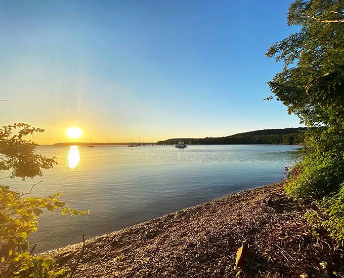Sunrise paints the bay with liquid gold, as boats drift peacefully in the distance &ndash; Door County's nightly masterpiece.