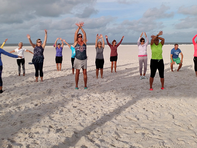 Beach yoga enthusiasts find their balance between earth and sky, arms raised in celebration of this perfect moment.