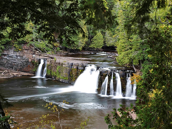 The waterfall's multiple channels create a symphony of sound and motion, each droplet playing its part in the grand aquatic orchestra.