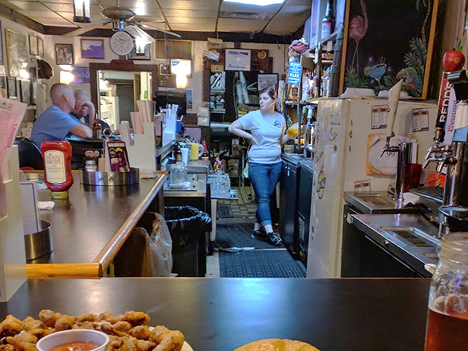 The bar area serves as command central, where friendly staff orchestrate the delicious chaos that keeps customers coming back for decades.
