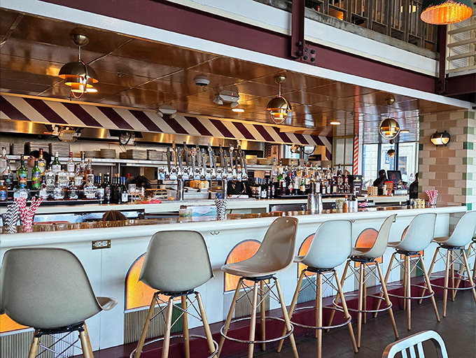 Sleek bar seating invites patrons to enjoy a drink alongside their pasta, the striped awning above adding a touch of old-school charm.