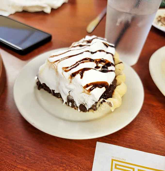 A slice of chocolate cream pie drizzled with chocolate sauce&mdash;proof that the simplest desserts are often the most profoundly satisfying.