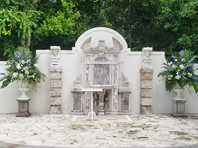 Marble elegance meets tropical splendor in this garden courtyard, where classical architecture finds harmony with palm fronds.