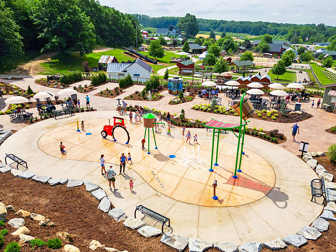 From above, the splash pad reveals its clever design, where tractor-themed water features create cooling fun on hot Michigan summer days.