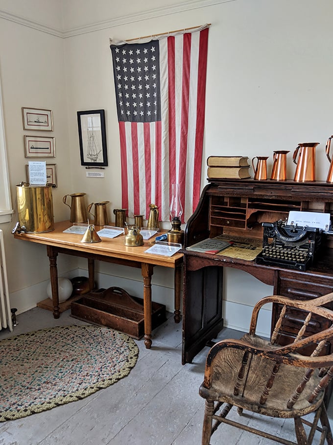 The keeper's office displays authentic artifacts including brass instruments, an American flag, and a vintage typewriter.