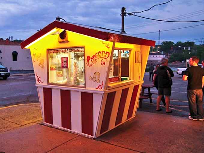 The Kiwanis Popcorn Stand glows invitingly at dusk, a beloved local landmark serving up buttery nostalgia in paper bags since generations past.