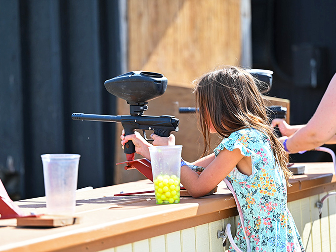 This young sharpshooter is learning that paintball requires both strategy and a willingness to accept colorful defeat with grace.