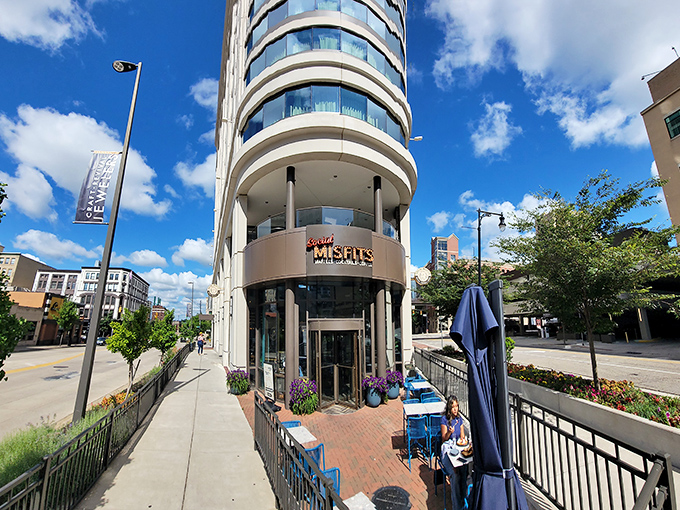 Blue chairs dot the outdoor patio, offering front-row seats to downtown Grand Rapids' vibrant street life and architectural beauty.