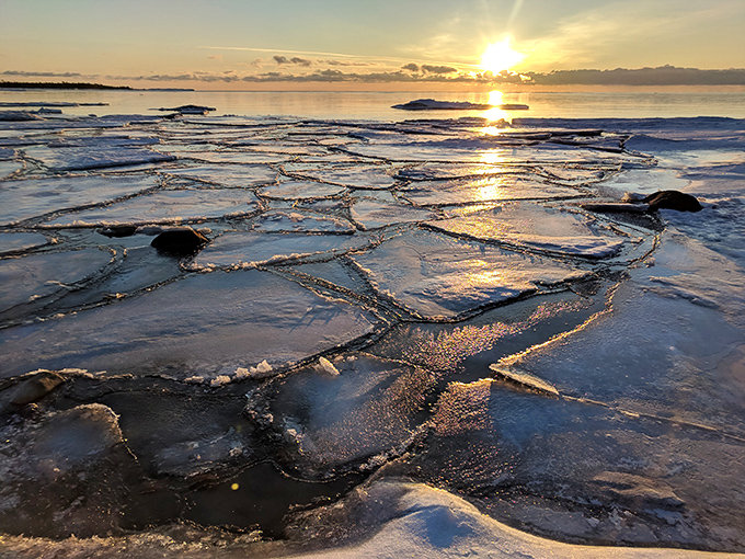 Shore: Winter transforms Lake Huron into a jigsaw puzzle of ice plates, creating a frozen mosaic that glows golden in the setting sun.
