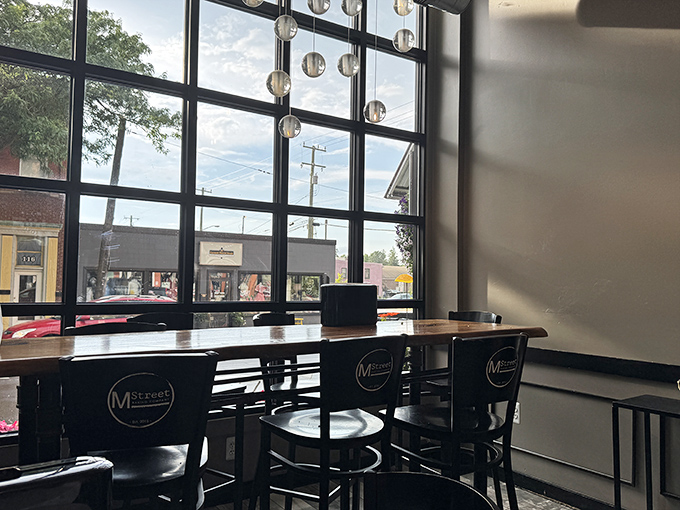 Sunlight streams through floor-to-ceiling windows, illuminating these cozy corner tables where dessert dreams and downtown views come together.