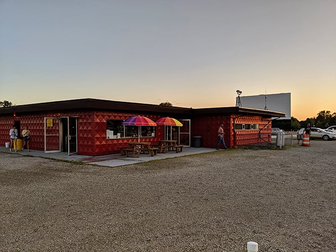 The Capri's snack bar building wears its vintage charm proudly, colorful umbrellas adding a festive touch to this temple of cinematic treats.