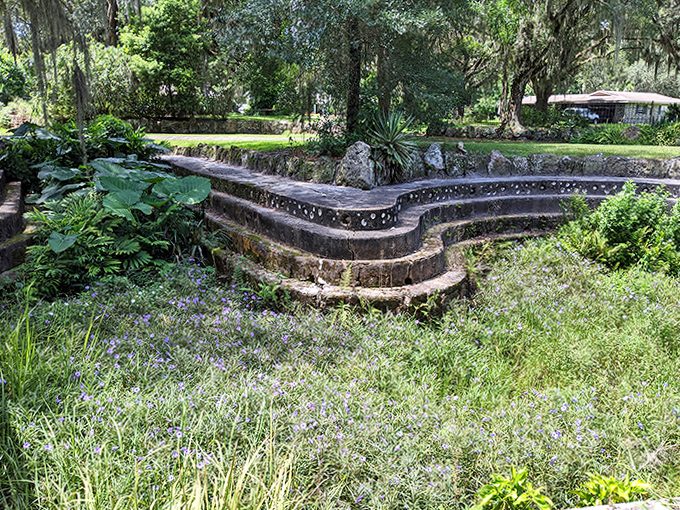 These curved stone steps cascade down like a miniature amphitheater, blending architectural elements with the natural landscape.