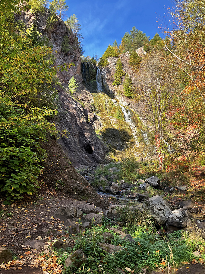 The waterfall and cave create a perfect geological duet. Water carved this landscape over millennia, proving patience creates the most spectacular results.