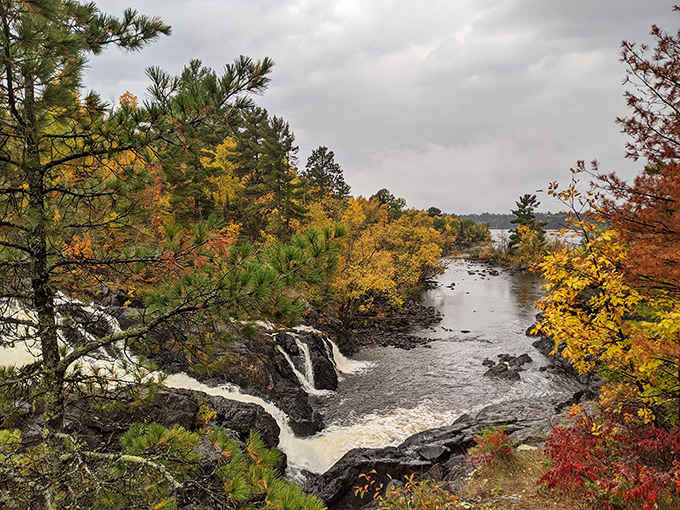 Autumn's double feature &ndash; fall foliage creates a frame of fiery colors around the falls, making photographers weak at the knees.