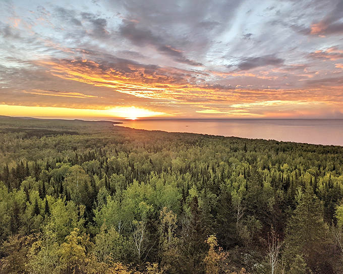 Sunset transforms Lake Superior into a mirror of fire, reflecting the sky's impossible palette across its vast surface.