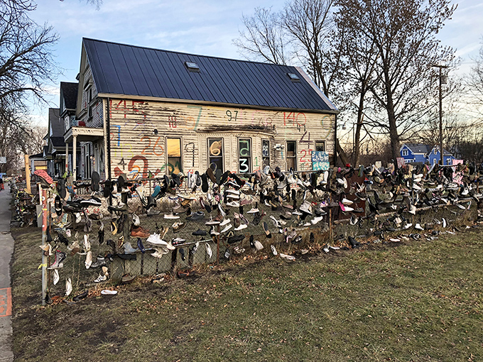 More shoes than a centipede convention, arranged with the careful randomness that defines the Heidelberg Project's aesthetic approach.