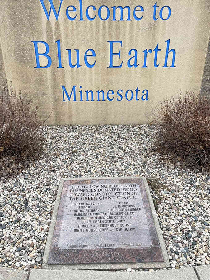 A commemorative plaque honors the Blue Earth businesses that contributed to the giant's construction, cementing their place in roadside attraction history.