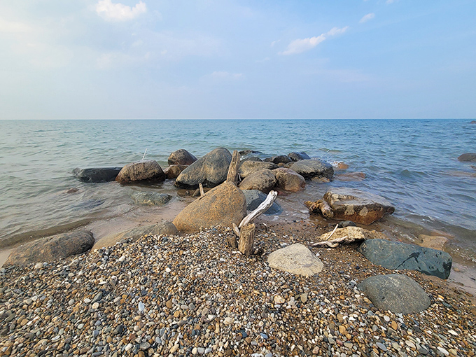 Ancient glacial rocks stand sentinel at the water's edge, smoothed by centuries of waves and countless Michigan winters.
