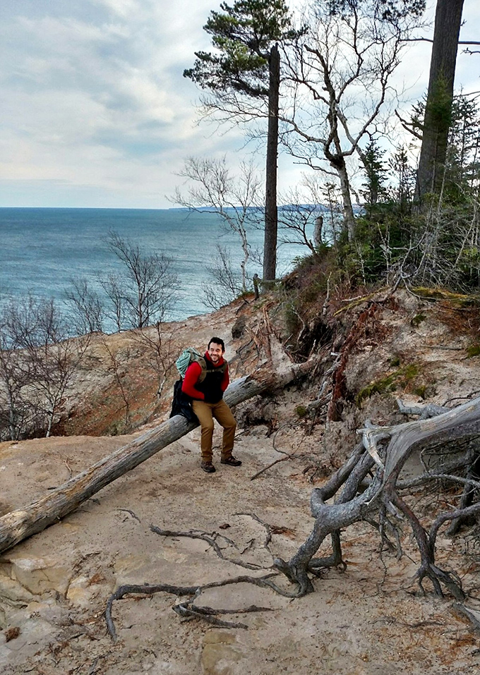 A hiker pauses to soak in the majesty, demonstrating the proper response to nature's grandeur: equal parts awe and photographic evidence.
